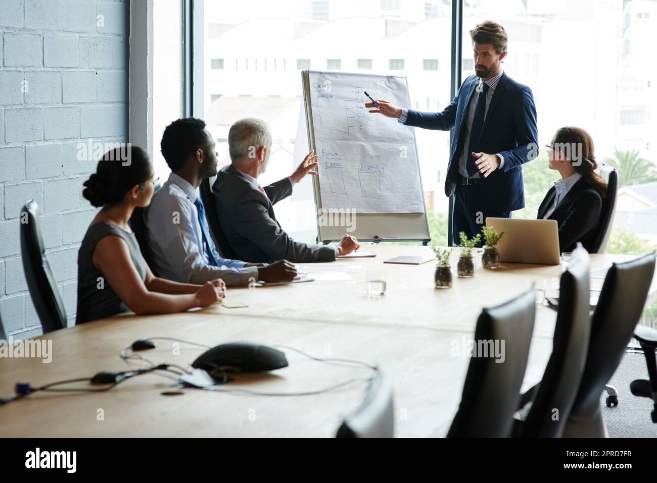 Confident businessman leading a presentation on a whiteboard with ...