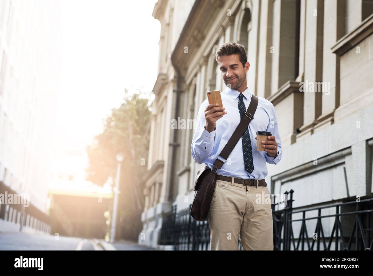 Who could be messaging me now. a handsome young businessman texting on ...