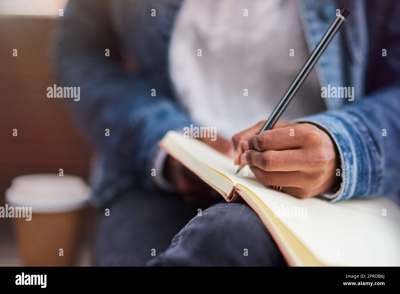 Its all in the notes. a young woman making notes while sitting outdoors ...