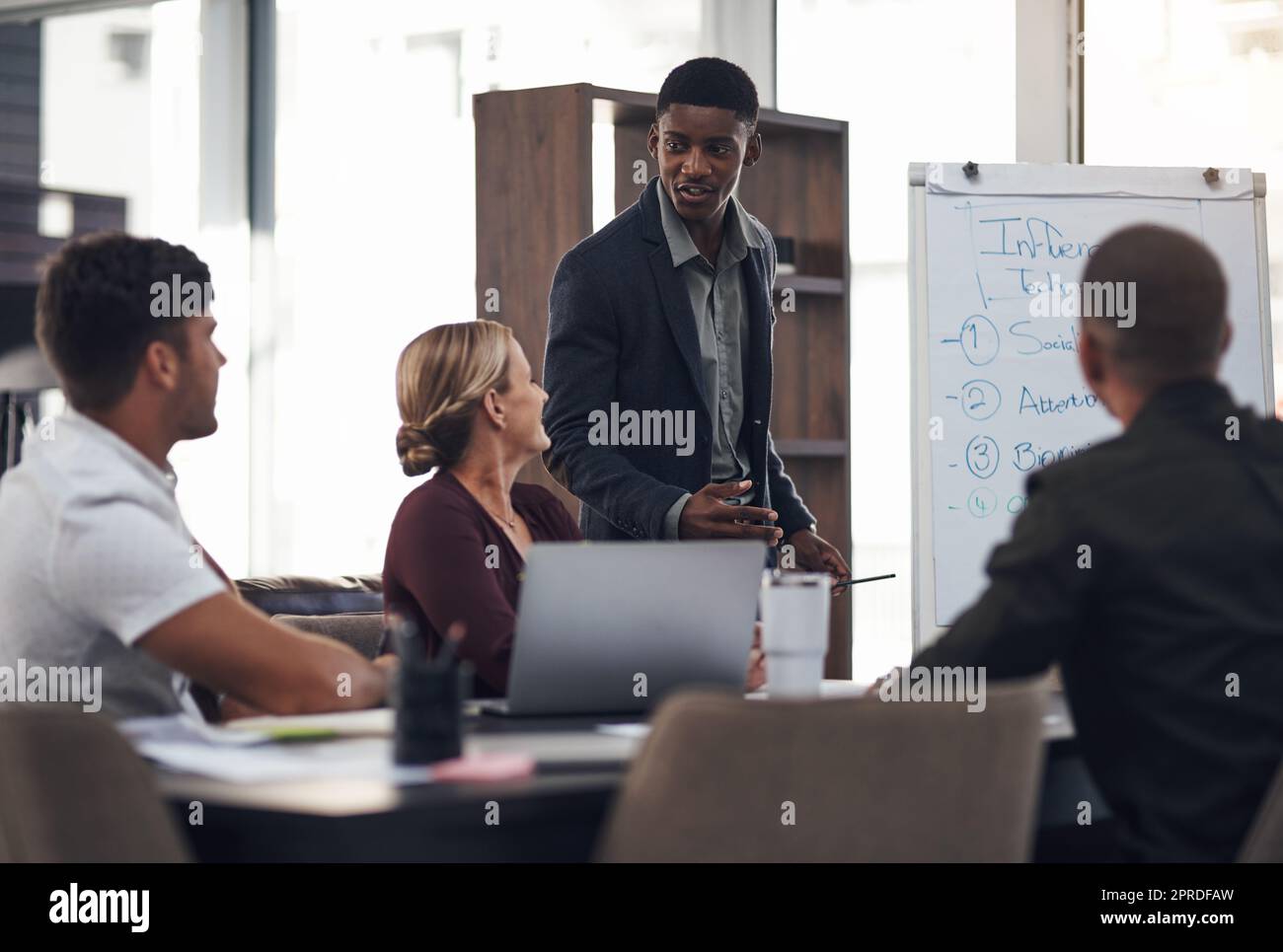 Sharing a new proposal with his team. a young businessman giving a ...