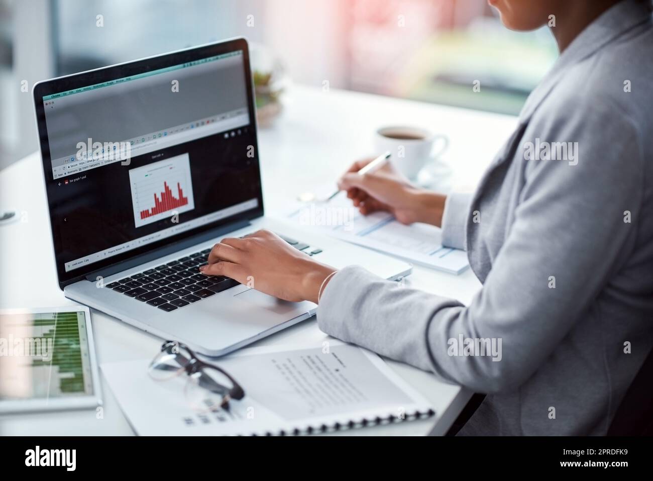 Business analyst with computer reading data, checking reports and ...