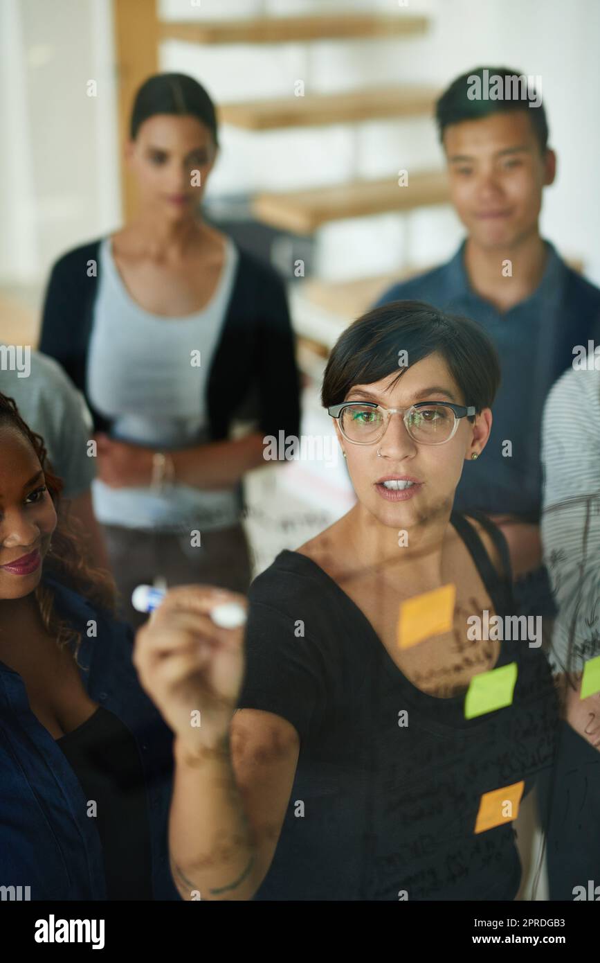 Brainstorming, diverse and creative team writing a strategy idea on ...