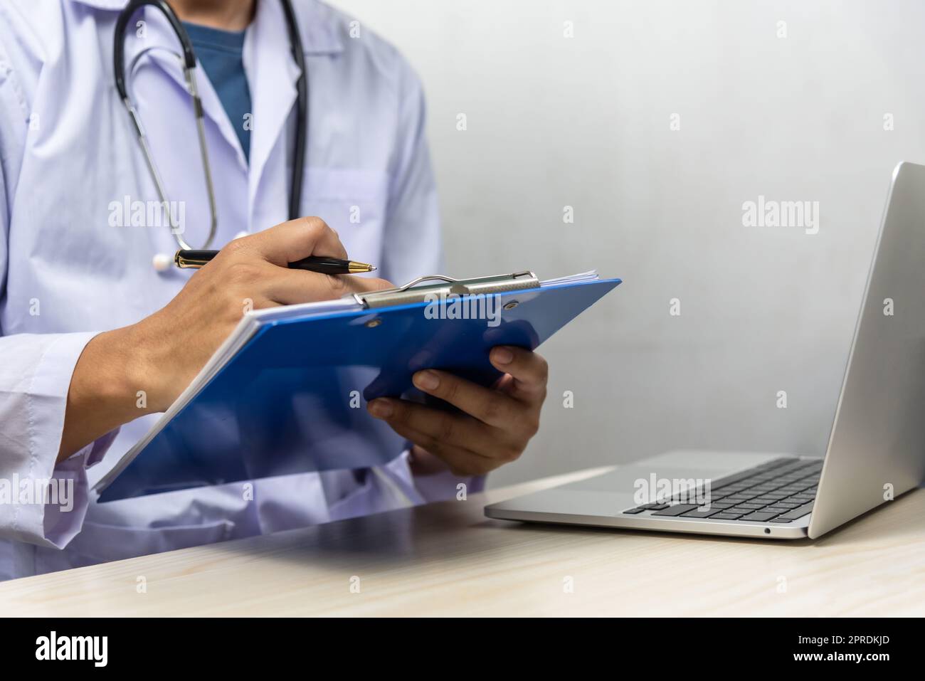 Doctor signs the patient paperwork at the desk.health care and ...