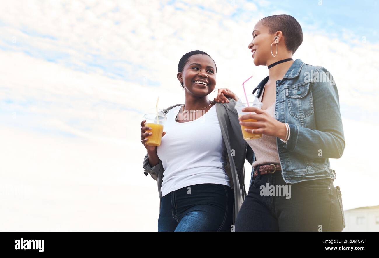 Making our way down town. Low angle shot of two young women walking in ...