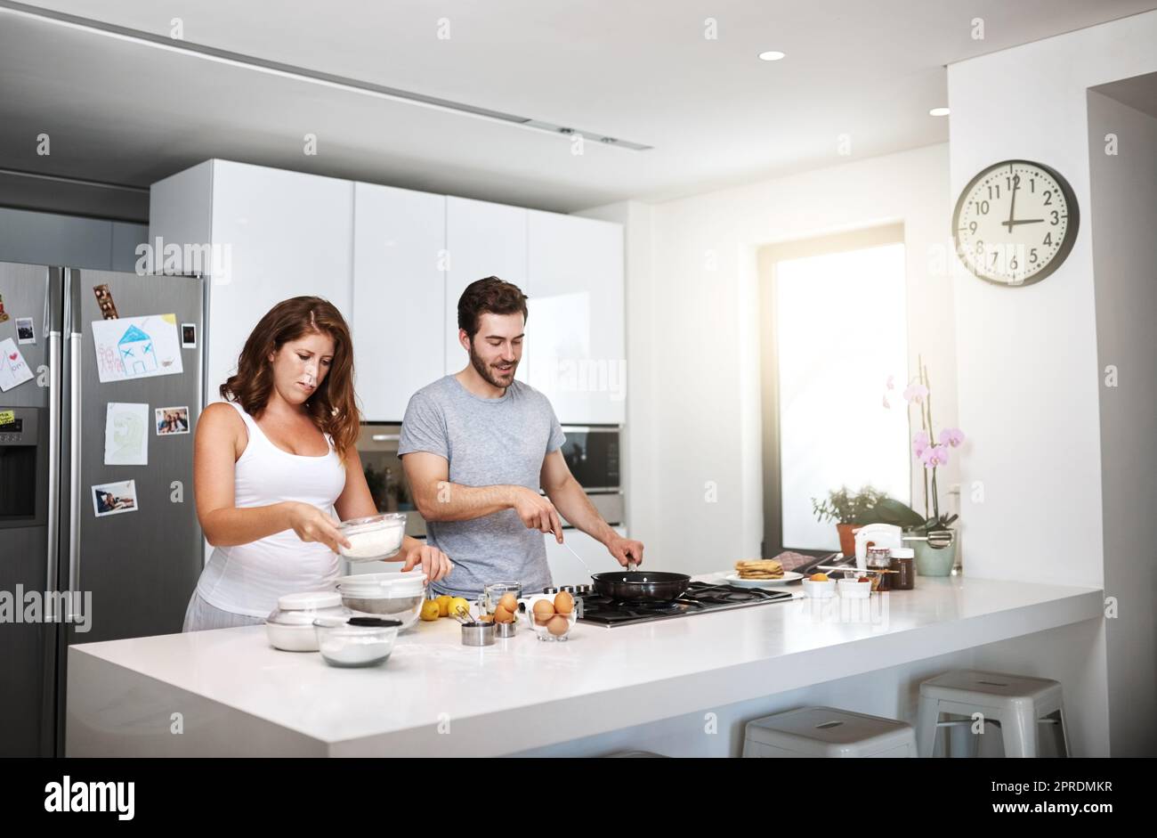 Together we can. a happy young couple preparing breakfast in the ...