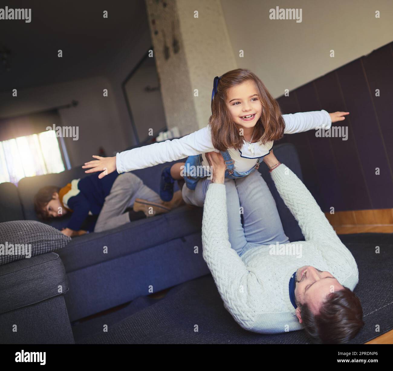 Take me higher. a man lifting his daughter into mid-air Stock Photo - Alamy