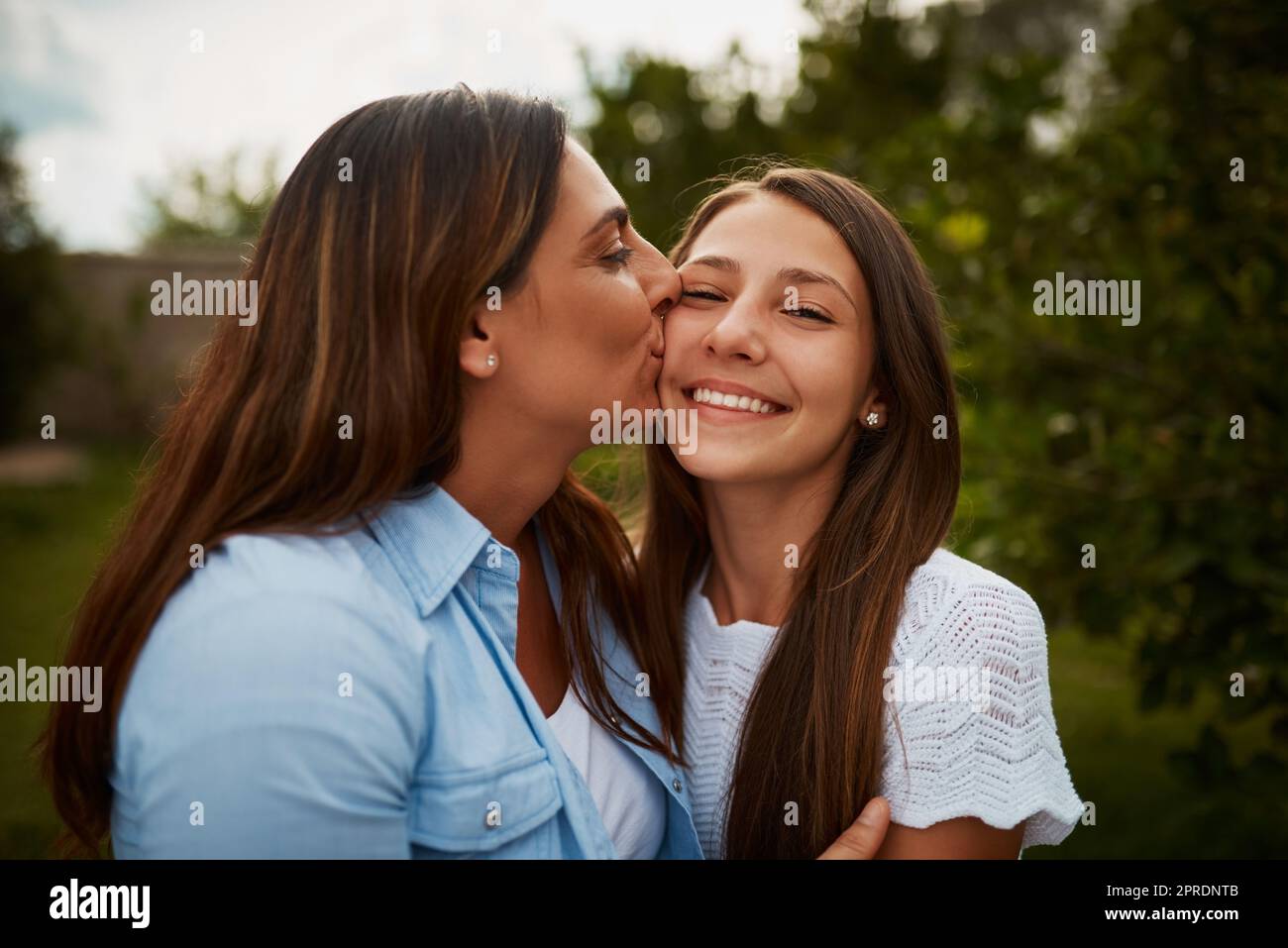You make me so proud. a young woman kissing her young daughter on the ...