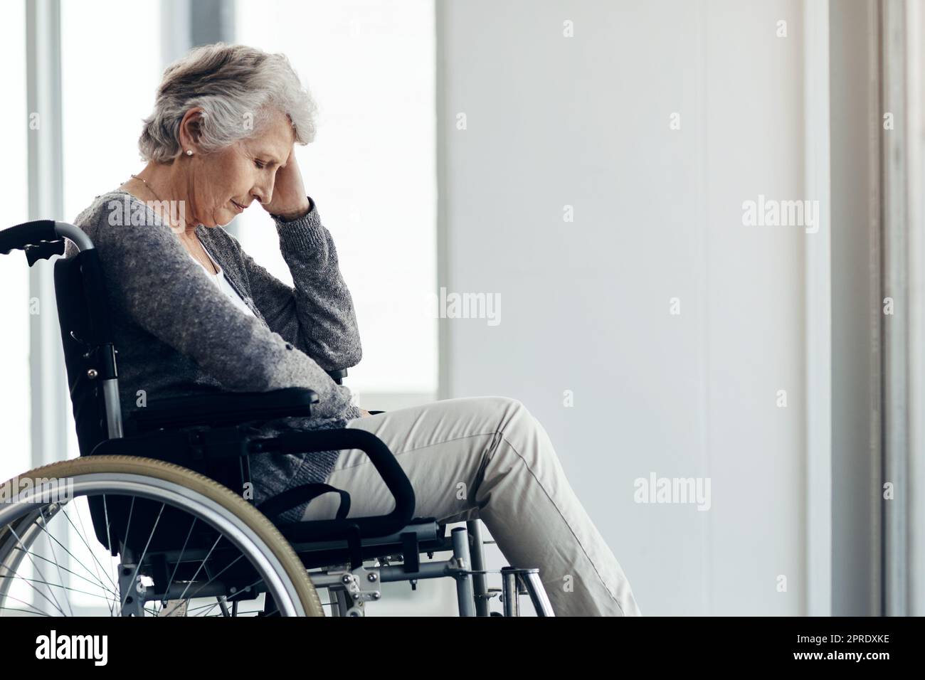 I hope someone comes to visit today. a senior woman sitting in a ...