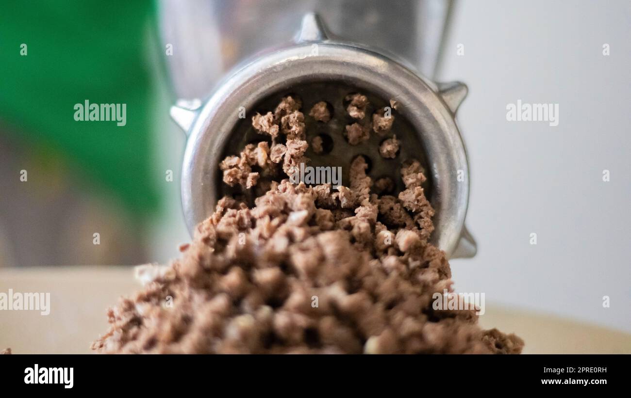 Minced meat in a manual mechanical meat grinder. Fresh boiled meat is ...