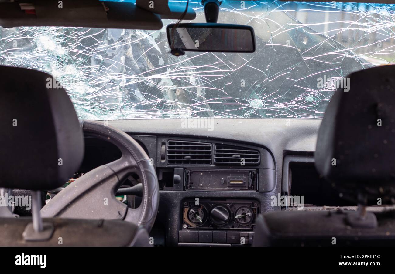 Damaged car window after an accident. Broken windshield as a result of ...