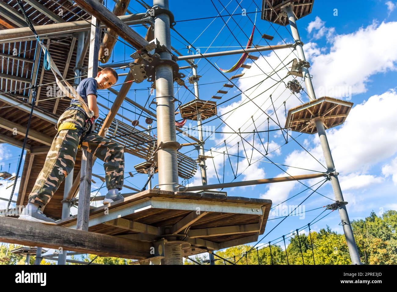 Child climbing in the high ropes course. Sport and adventure concept ...