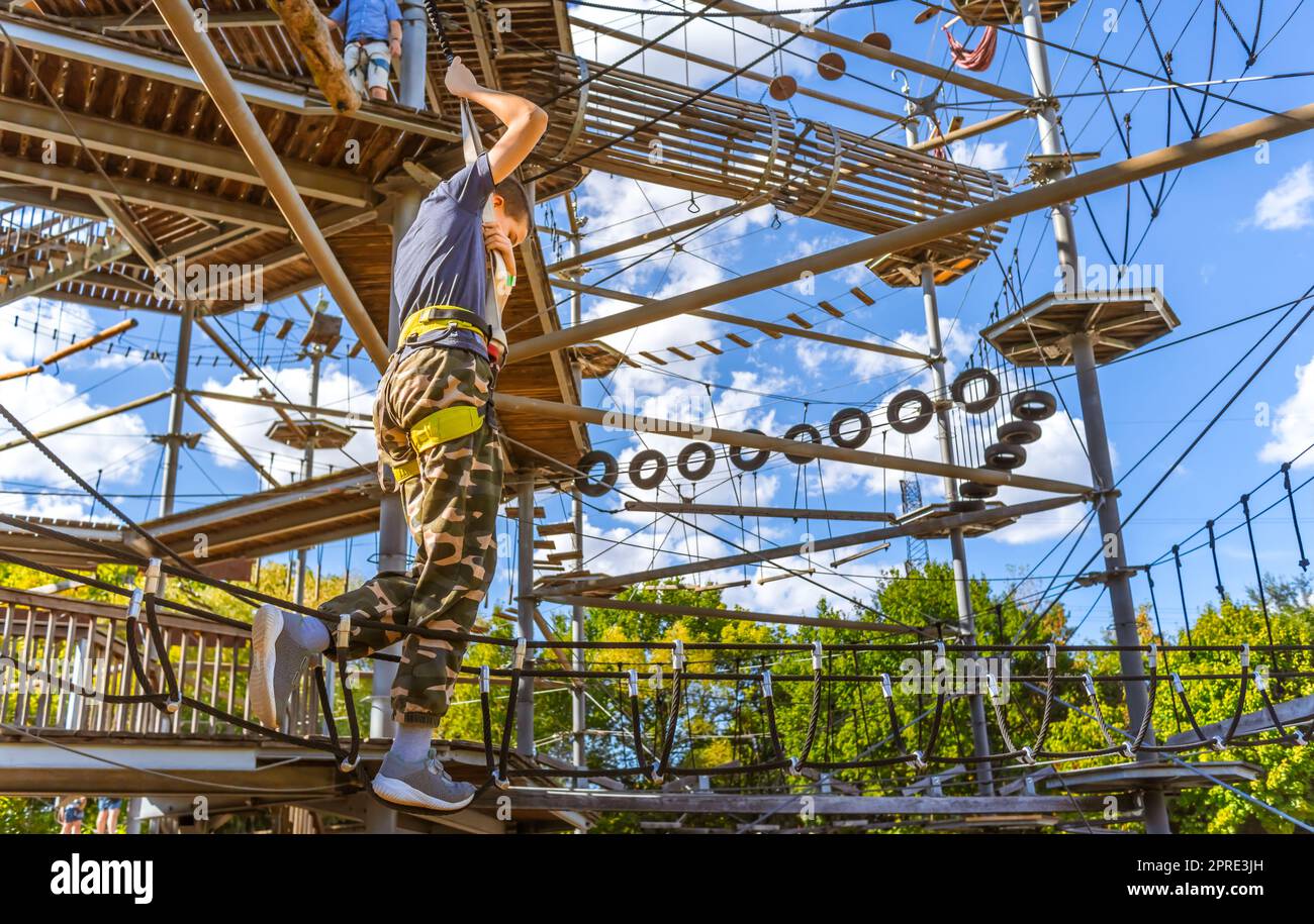 Child climbing in the high ropes course. Sport and adventure concept ...