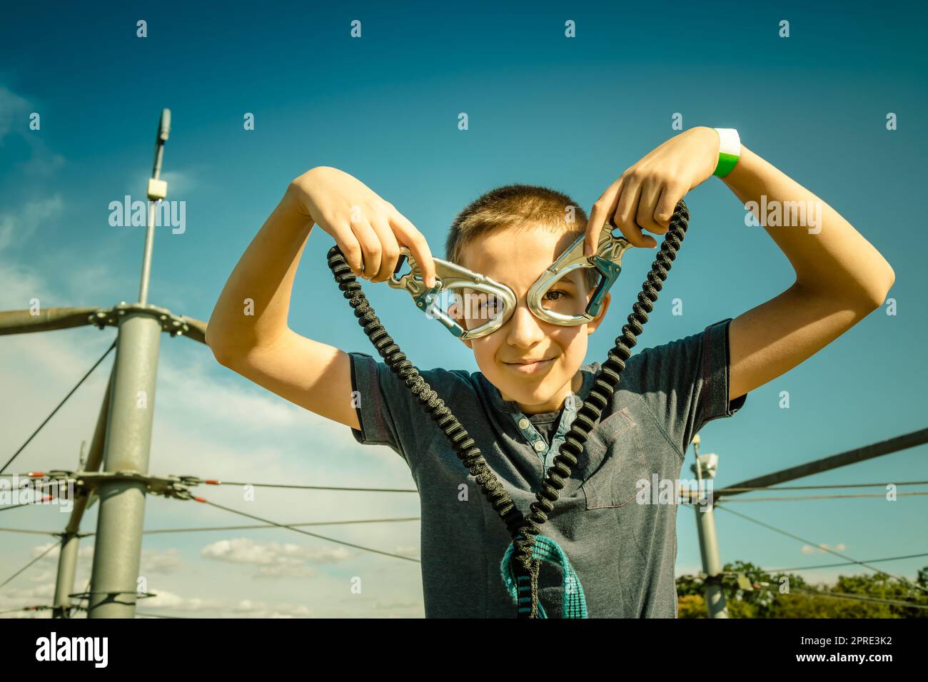 Zipline equipment for safety, adventure in high ropes course. Happy boy ...