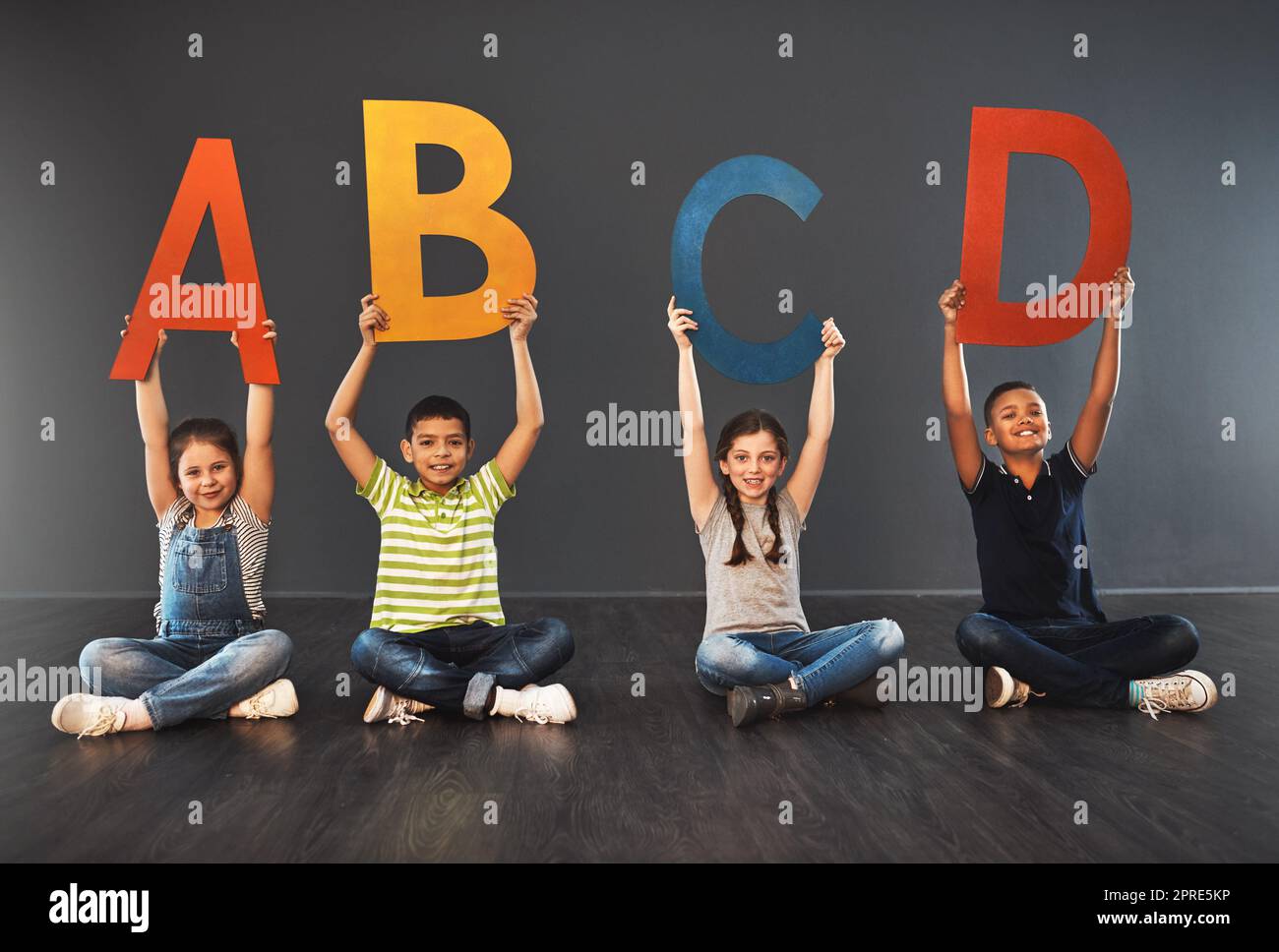 Children holding alphabet letters hi-res stock photography and images ...