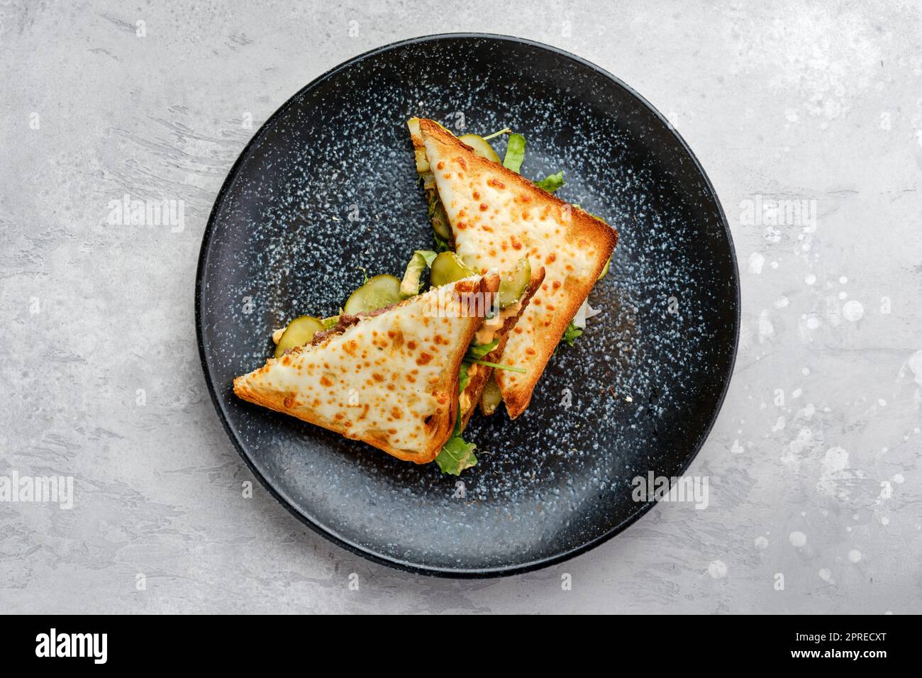 Top view of sandwich with beef, pickled cucumber and cheese cut on ...