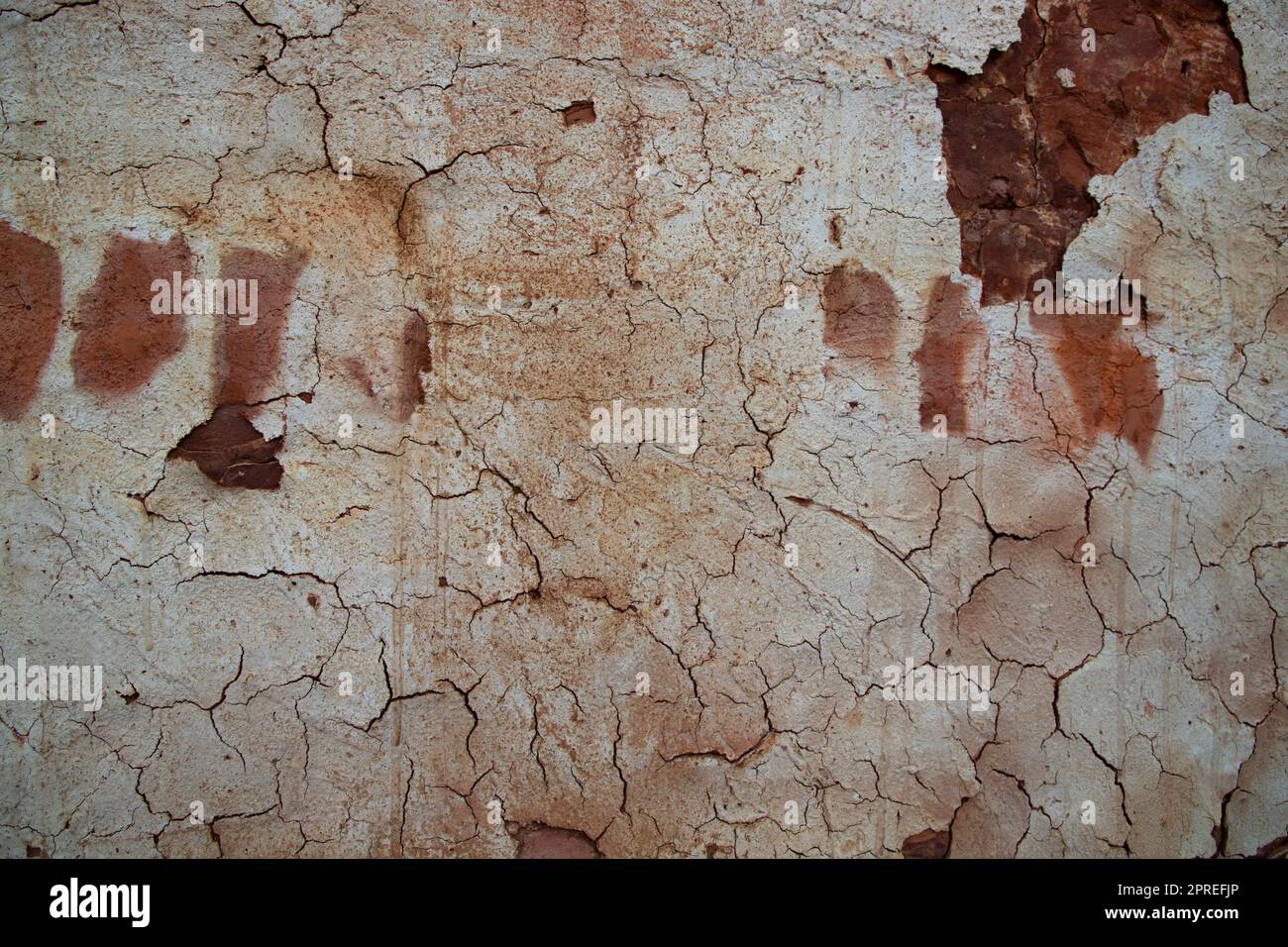 The texture of a brown concrete wall with cracks and scratches can be ...