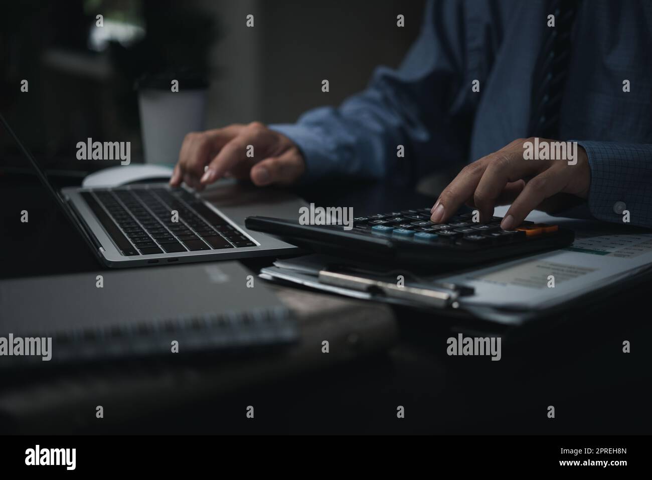 Man accountant using calculator and laptop computer in office.Business ...
