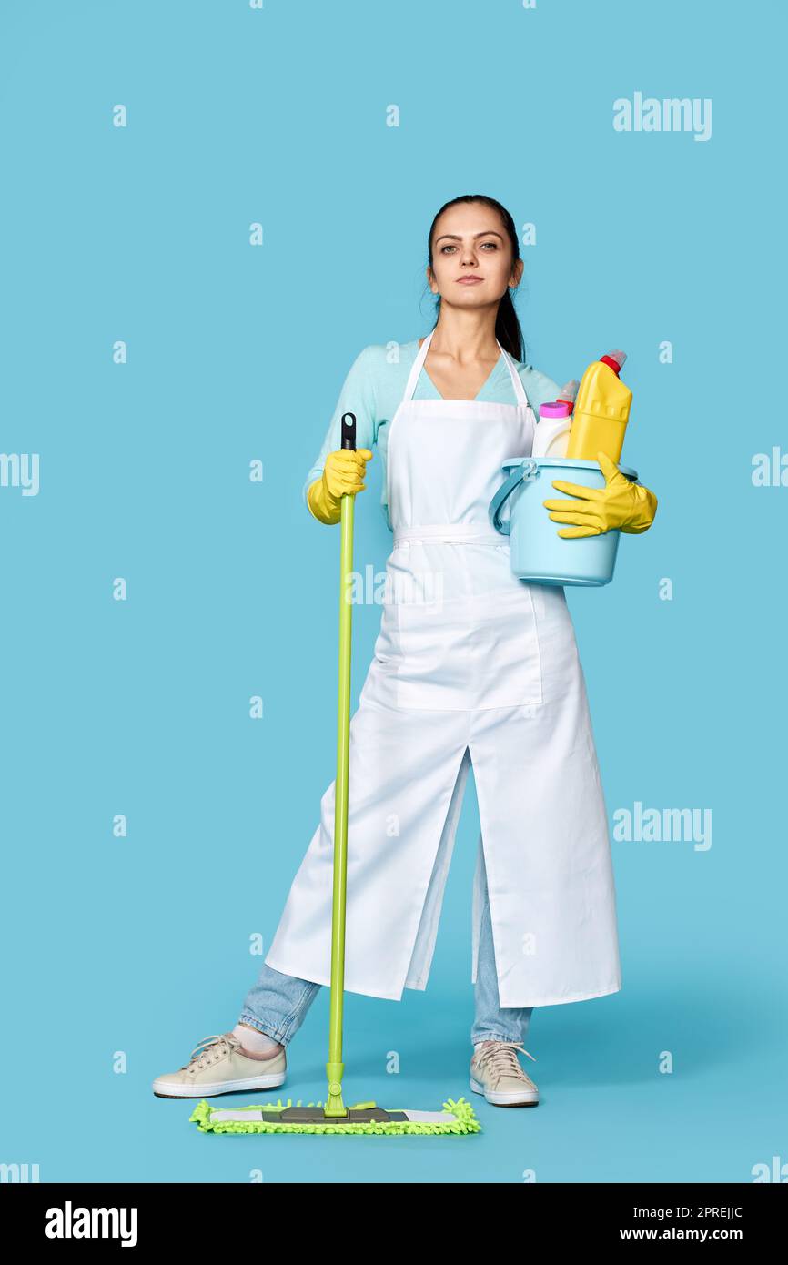 pretty woman in rubber gloves and cleaner apron with cleaning supplies ...
