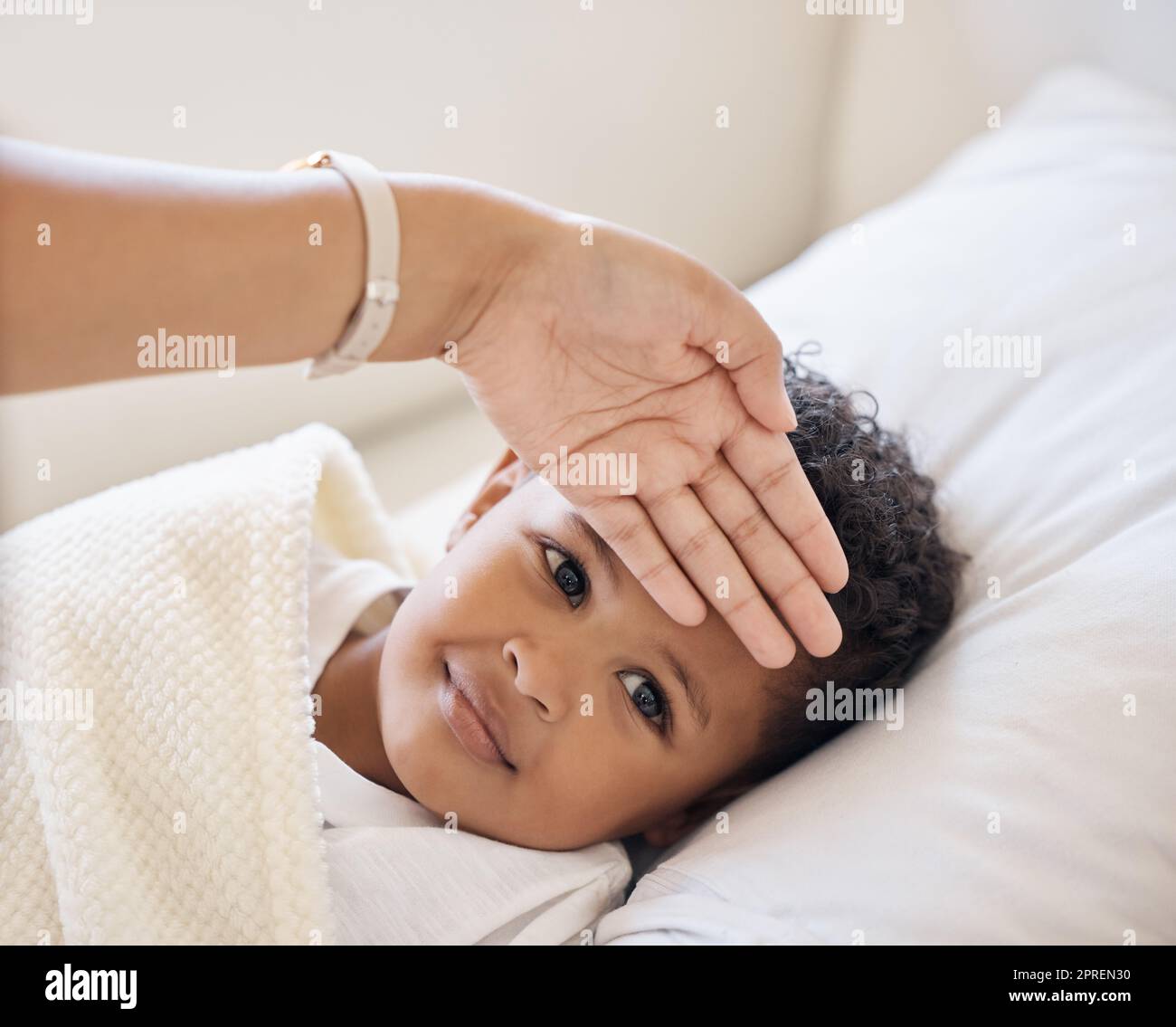 Closeup shot of a cute mixed race little boy feeling unwell and looking ...