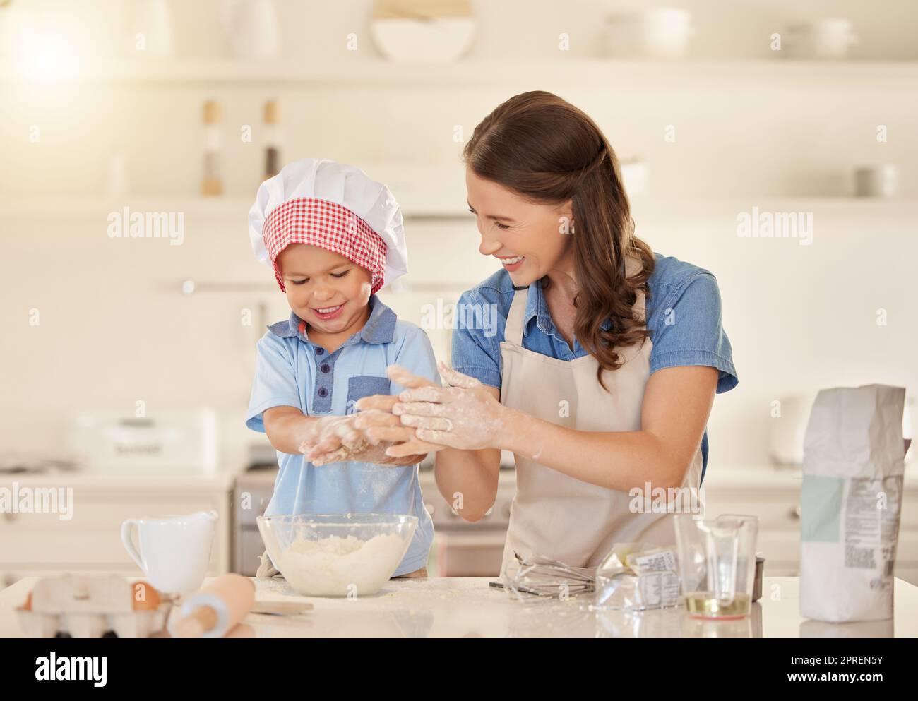 Making some delicious treats. a young mother baking with her son Stock ...