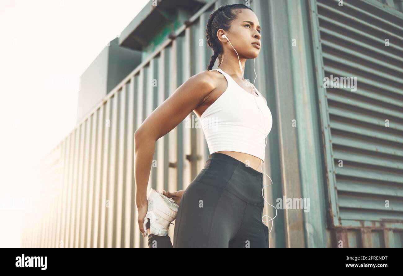 One fit young hispanic woman from below listening to music with ...