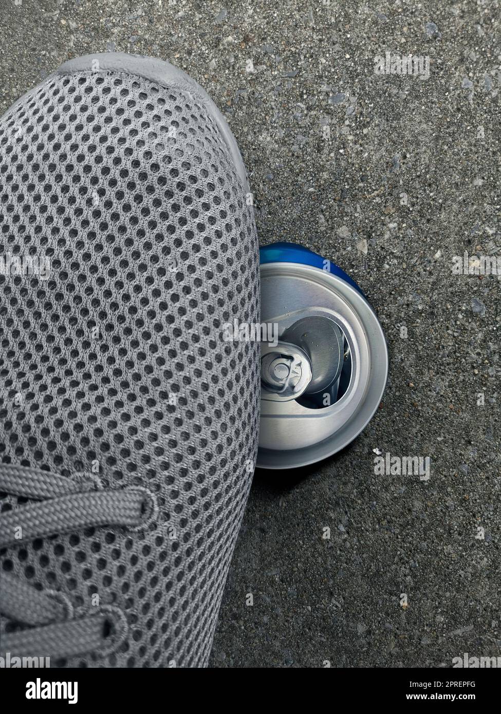 A man stepped stepping compressed cans on cement ground Stock Photo - Alamy
