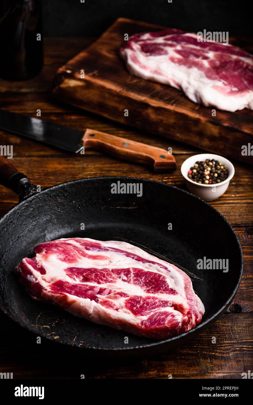 Raw pork neck steak in cast iron skillet Stock Photo - Alamy