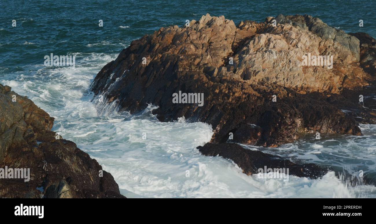 Ocean waves splash against rock on island Stock Photo - Alamy