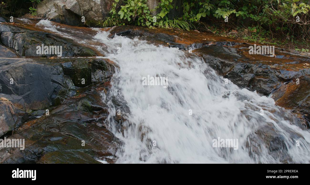 Waterfall flowing from the cliff in forest Stock Photo - Alamy