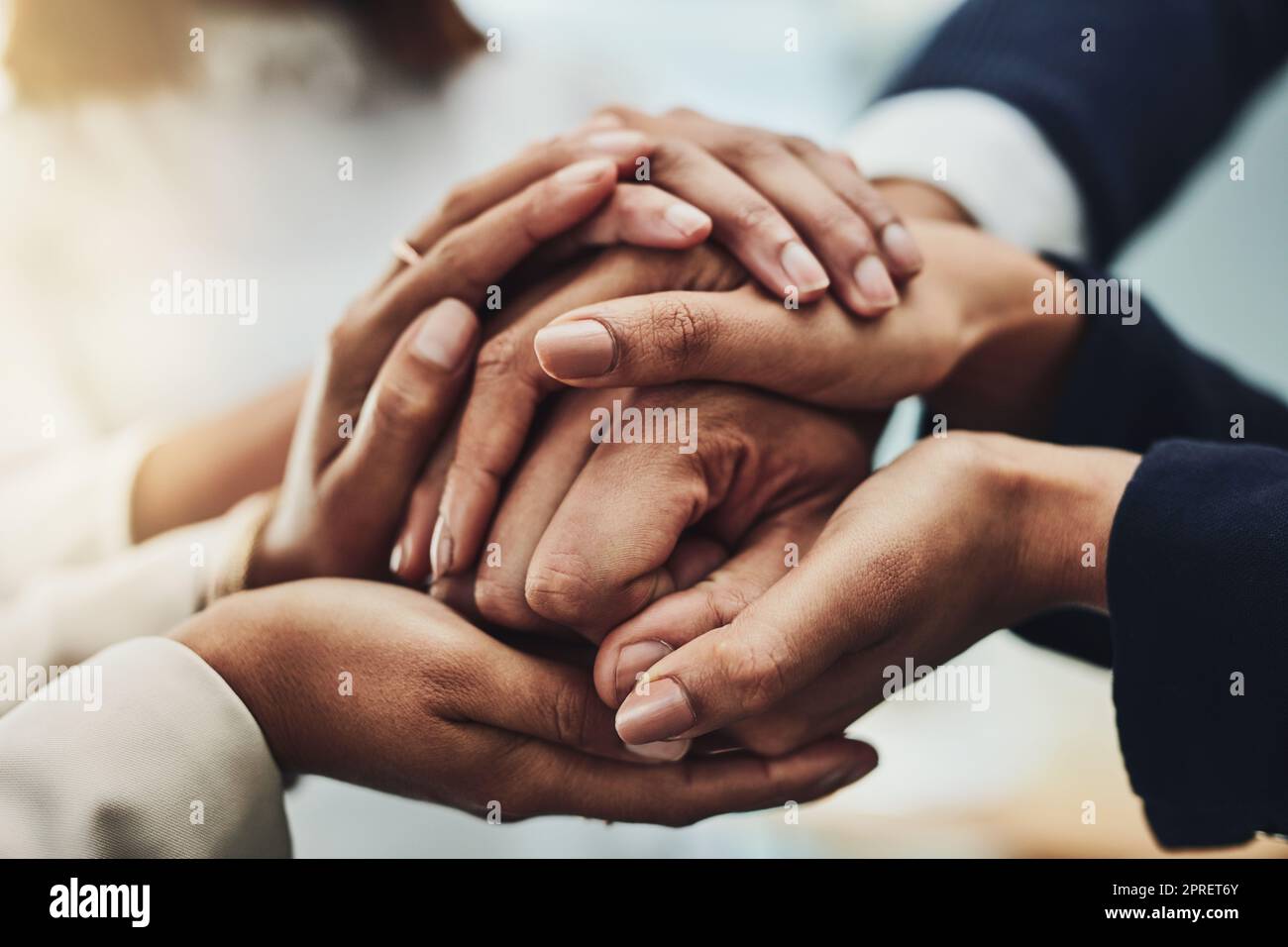 Business people holding hands for support, motivation and comfort ...