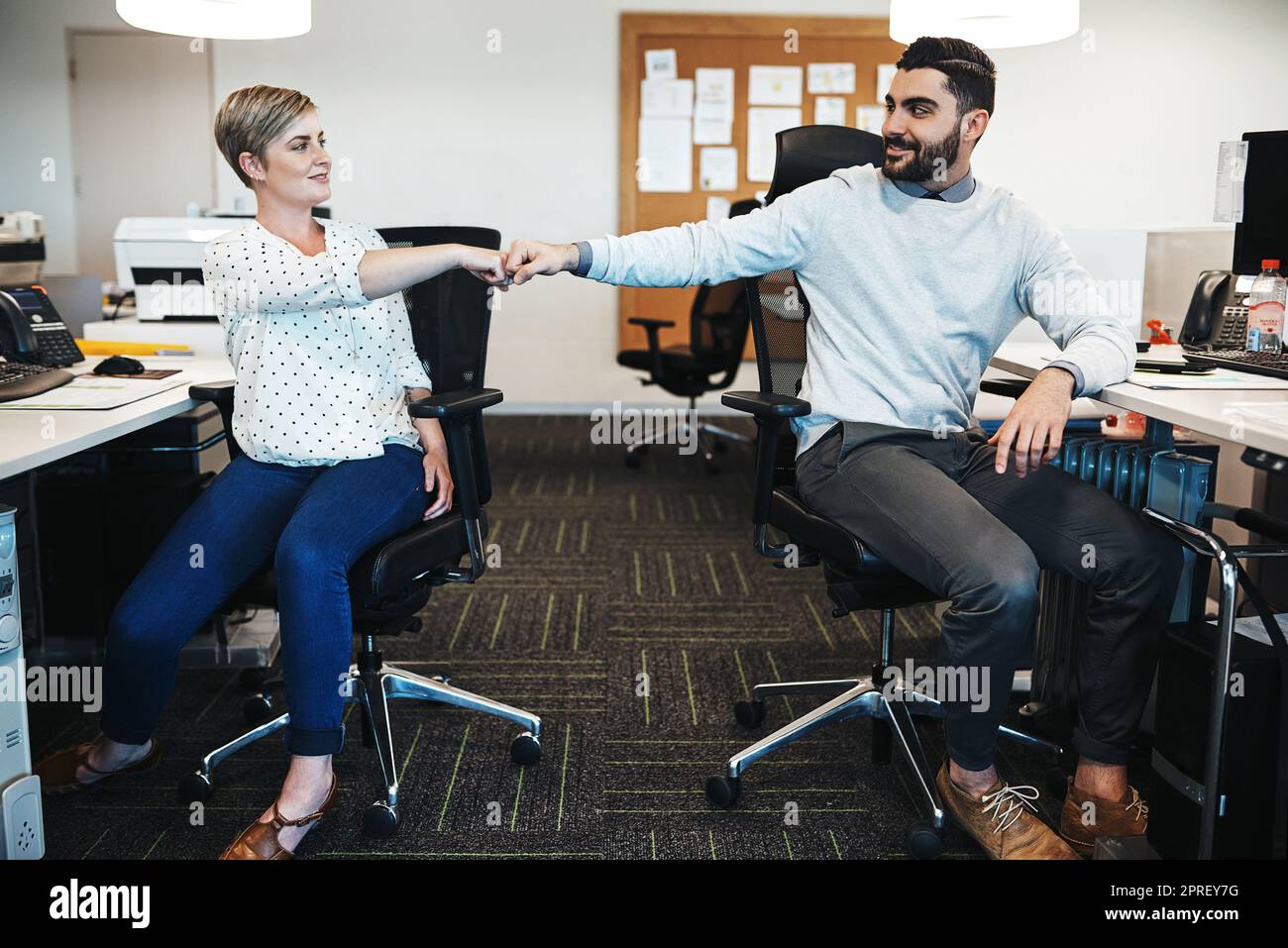 We got this. creative colleagues giving each other a fist pound in the ...