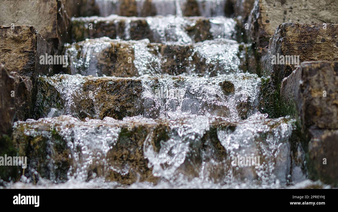 waterfall over a stone staircase. a stream flowing through a park ...