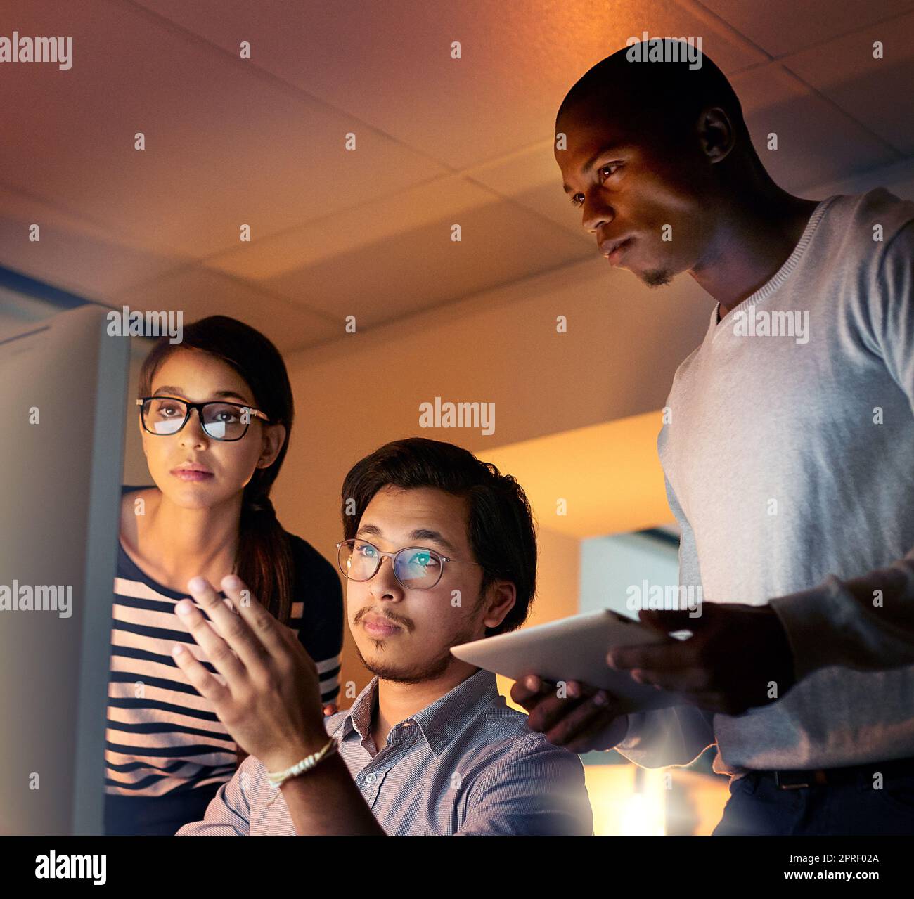 Collaboration is the key to success. colleagues looking at something on ...