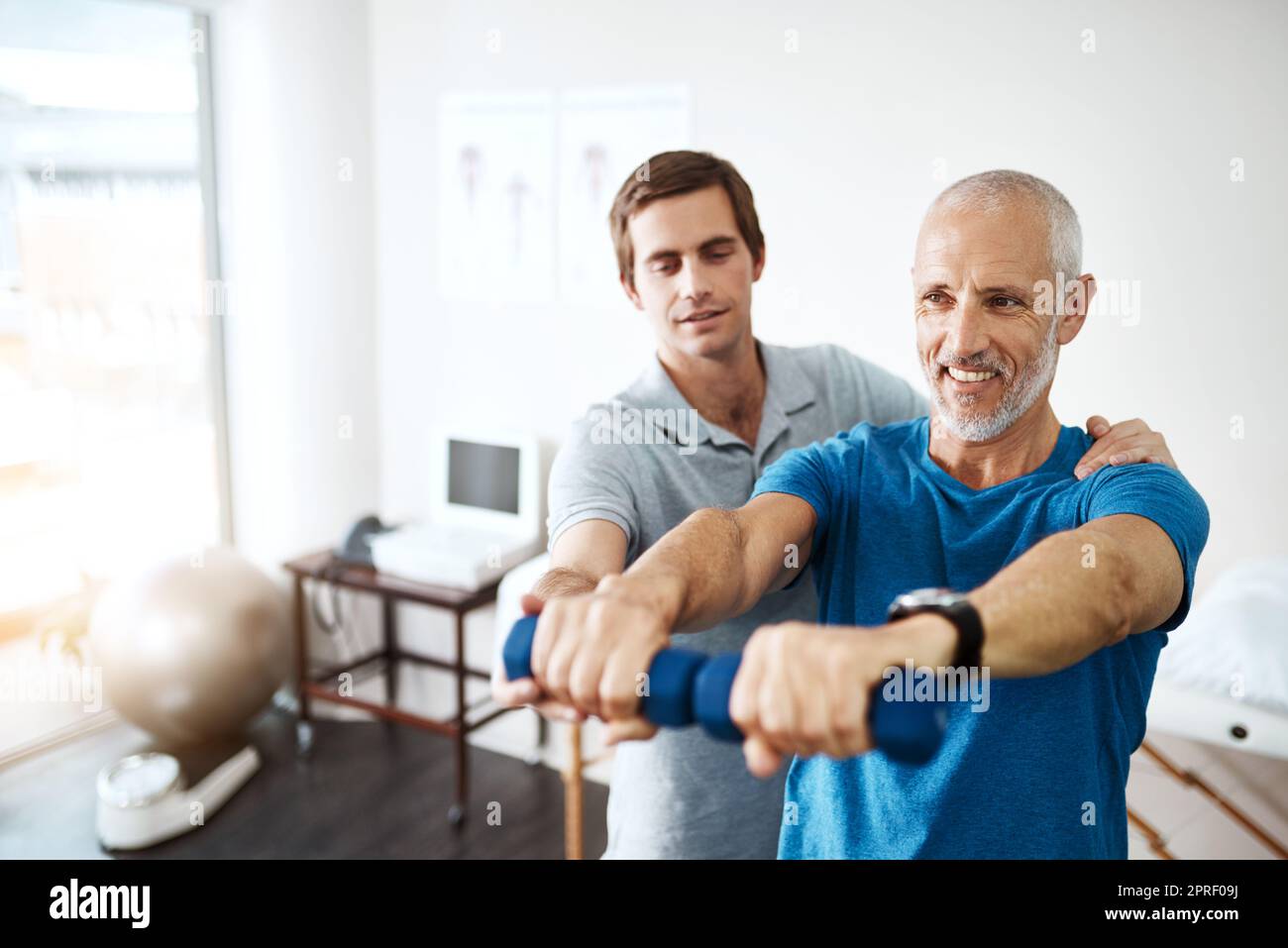 Hands together. a young male physiotherapist helping a client with ...