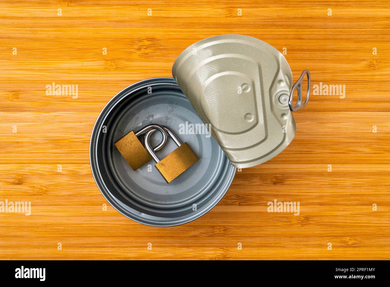 Tin can with a two linked brass padlocks. Privacy and security concept ...