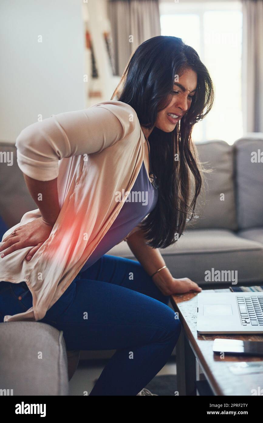 Feeling the strain on her lower back. a young woman suffering with ...