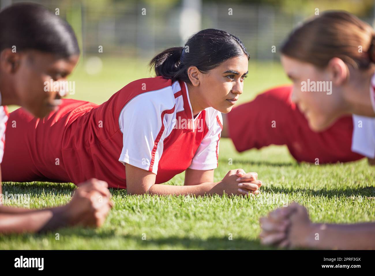 Women soccer players in a team doing the plank fitness exercise in ...