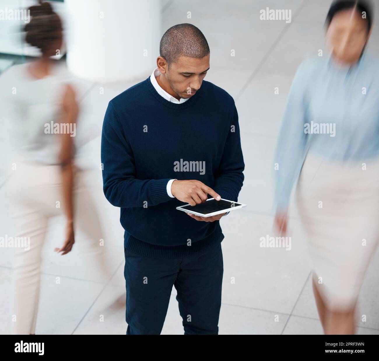 Busy office with business man on tablet browsing, planning and ...