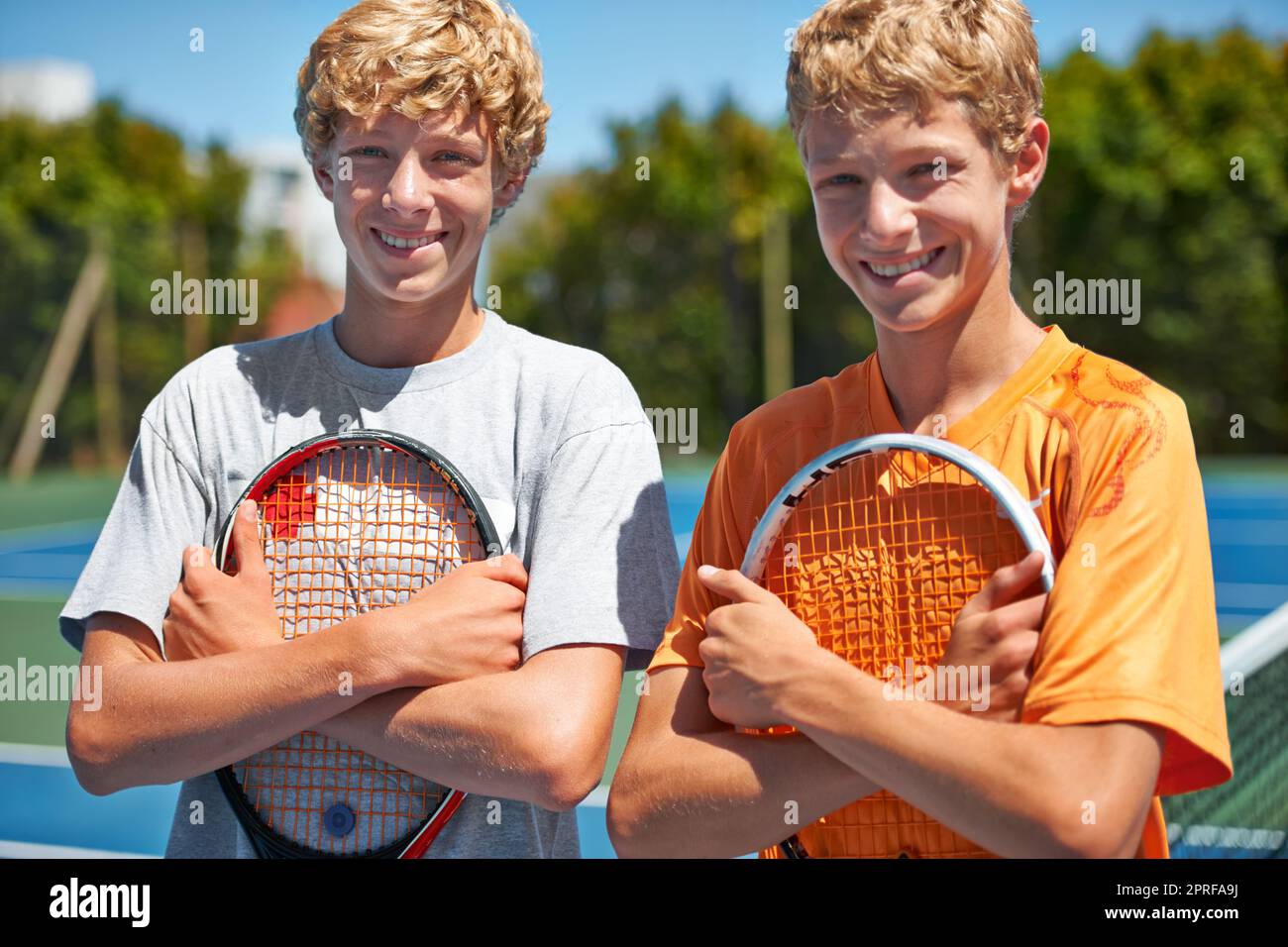 Tennis is their sport of choice. Two friends standing together and ...