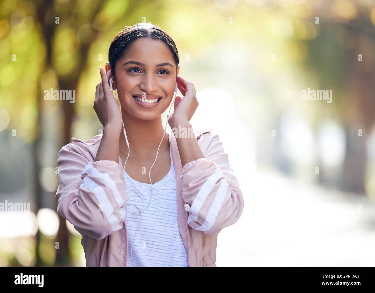 These beats are the best for my runs. a sporty young woman listening to ...