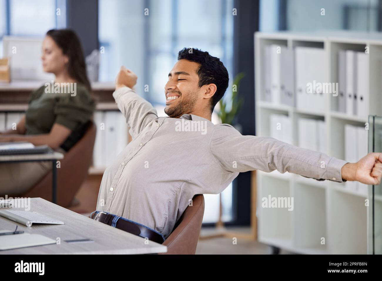 I need some air. a young call center agent stretching before taking his ...