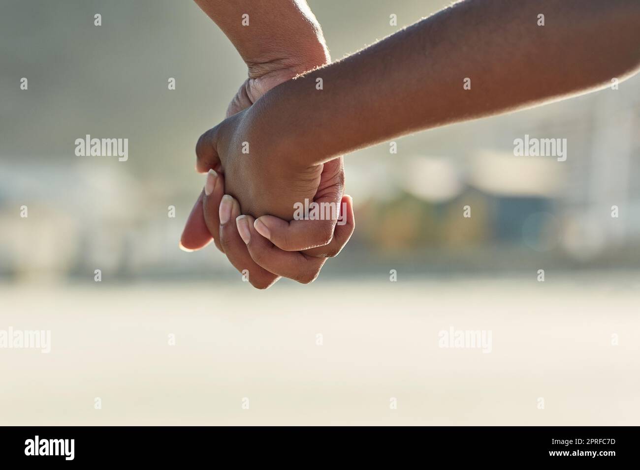 Hand in hand. Closeup shot of an adult holding a childs hand outside ...