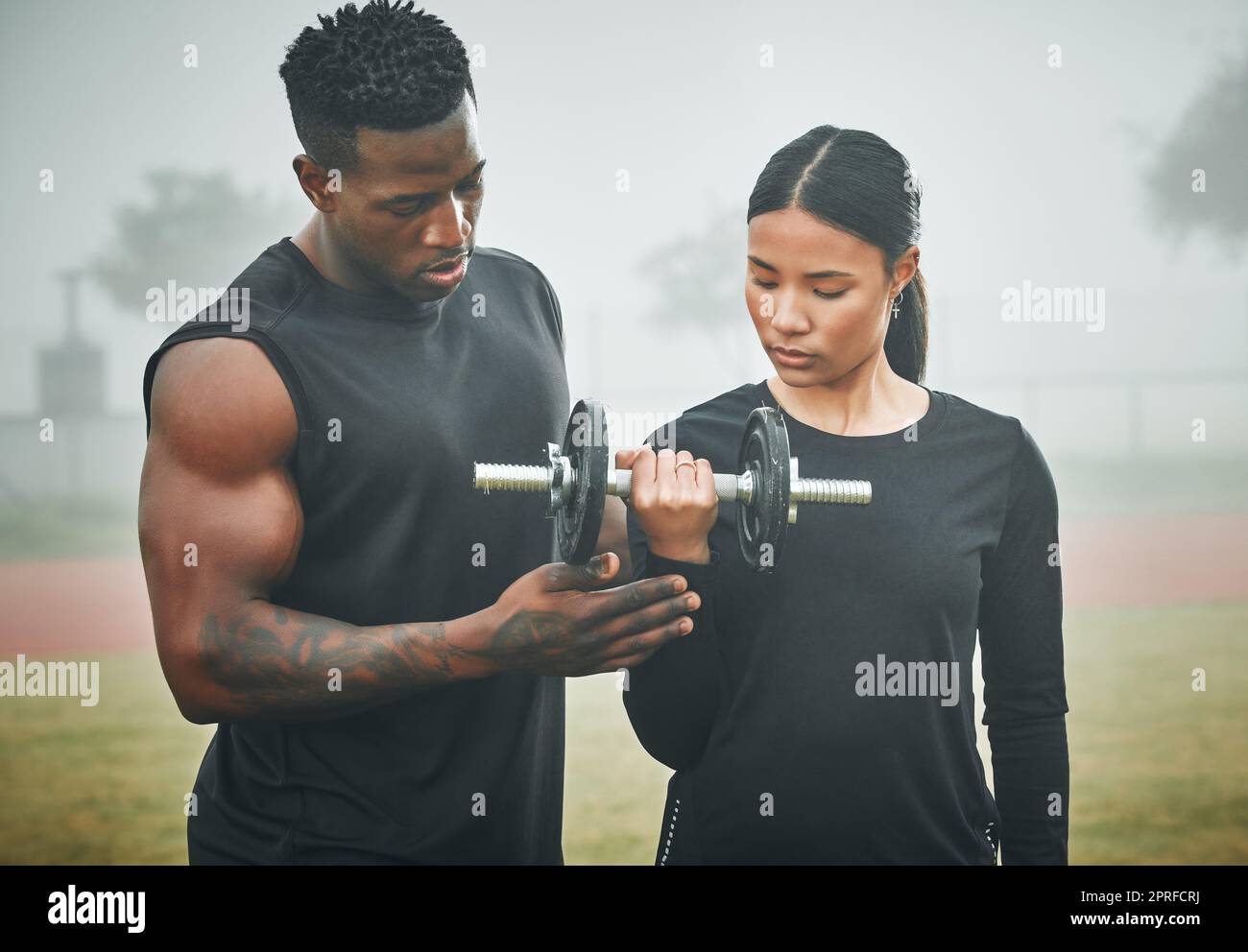 Feel the power flowing from your muscles. a sporty young woman exercising with dumbbells with ...