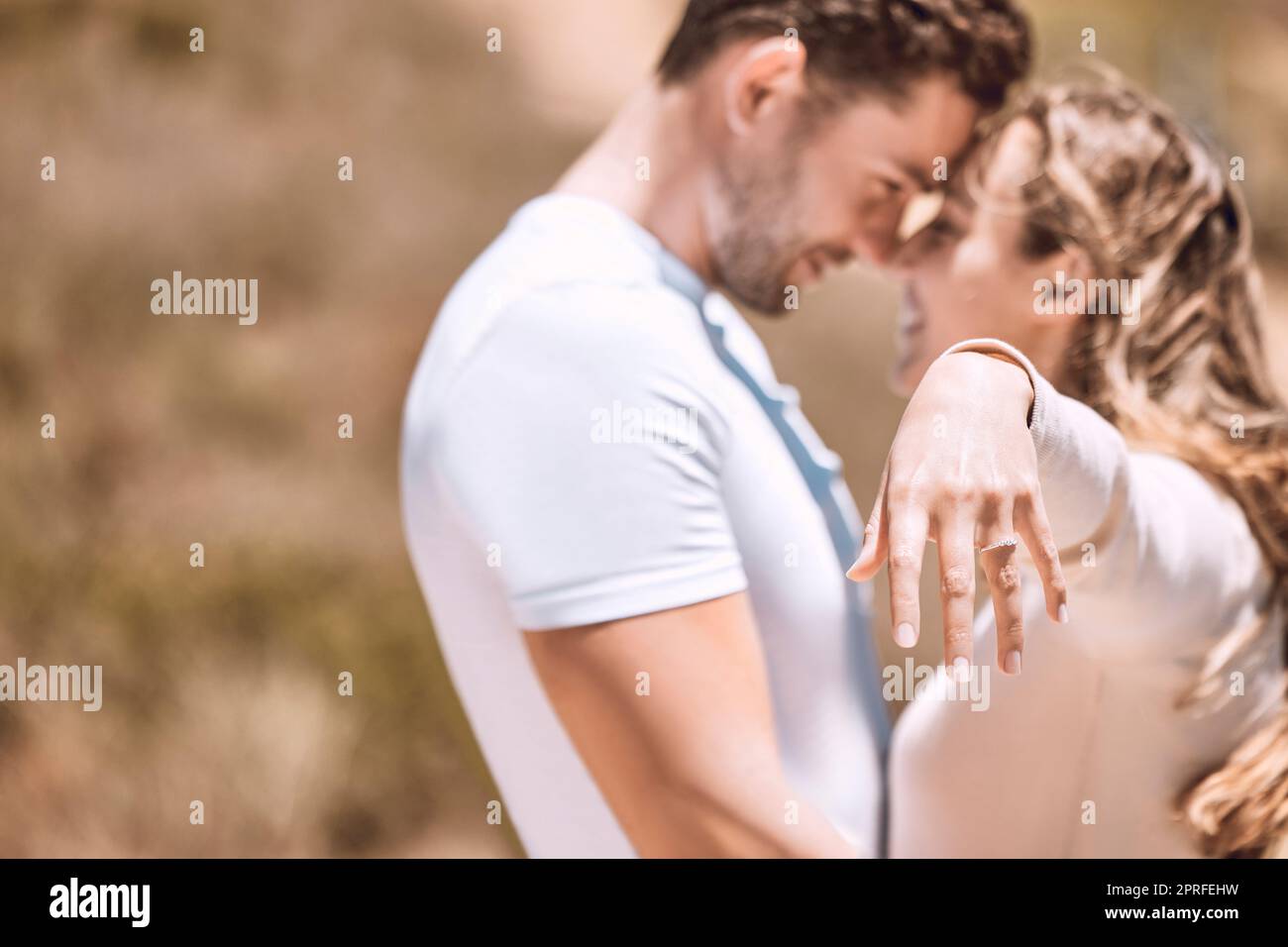 Female hand wearing engagement ring and romantic couple in love after ...