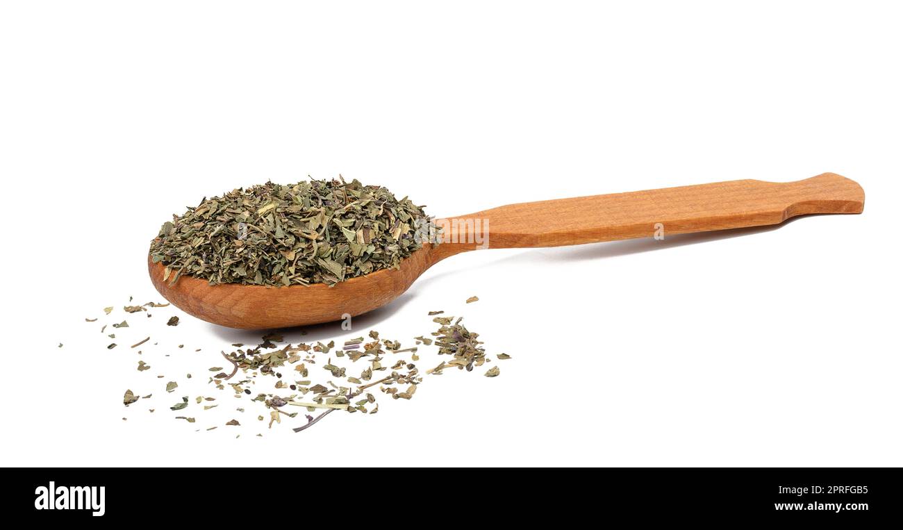 Crushed basil leaves in a brown wooden spoon Stock Photo - Alamy
