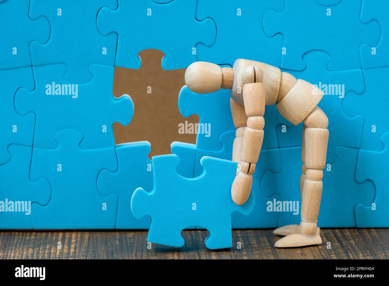 Dummy assembling last missing puzzle on puzzle wall Stock Photo - Alamy