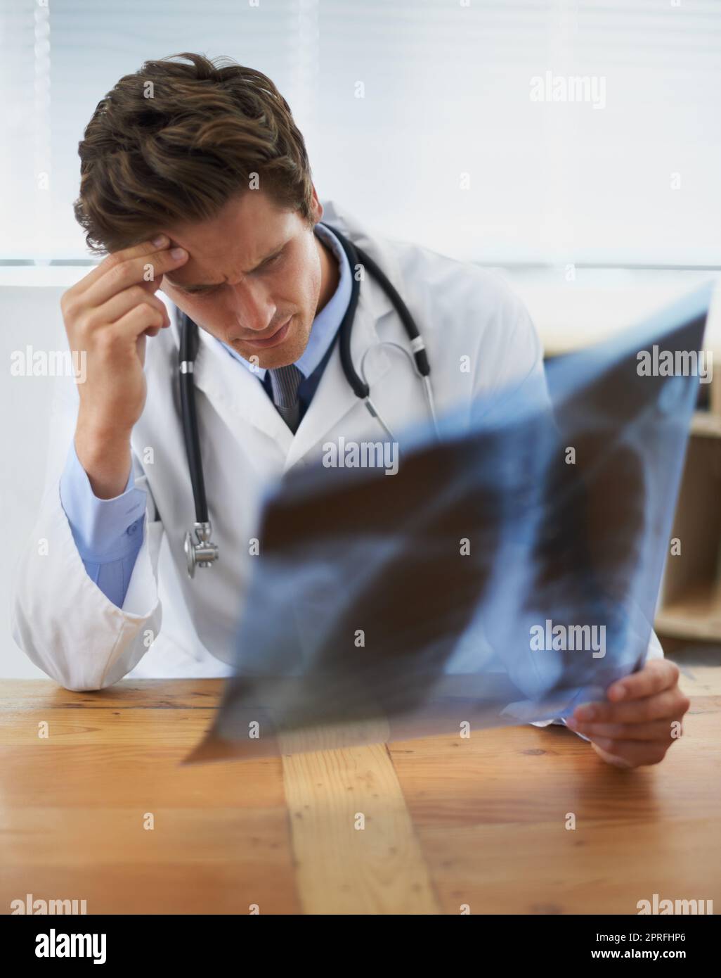 This looks serious. a concerned-looking young doctor examining a chest ...