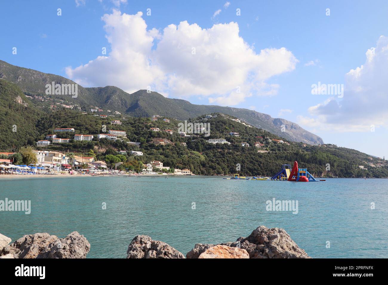 Beautiful beach in Ipsos on Corfu, tourists enjoying a nice summer day ...