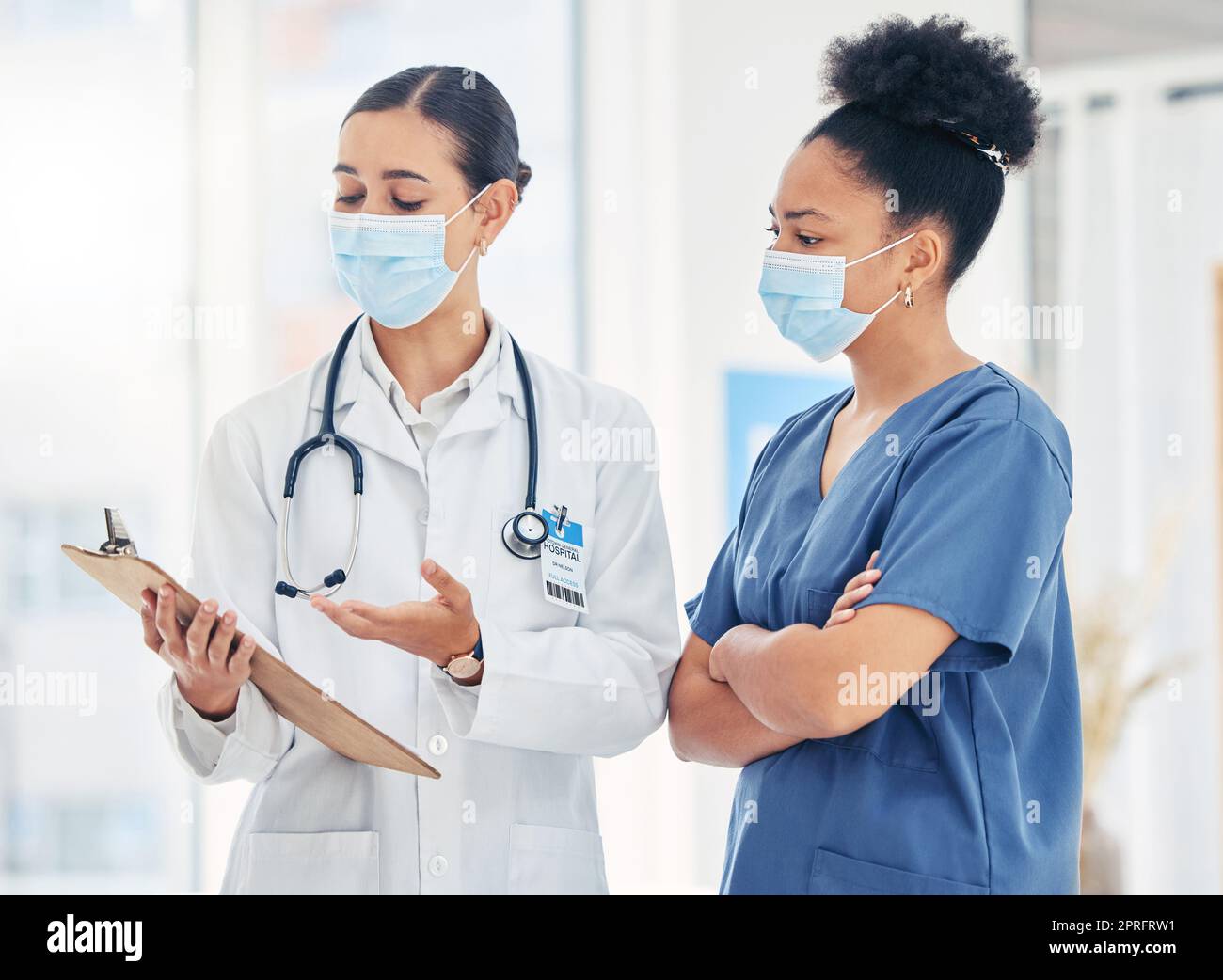 Doctor and nurse reading medical information paperwork with mask for ...