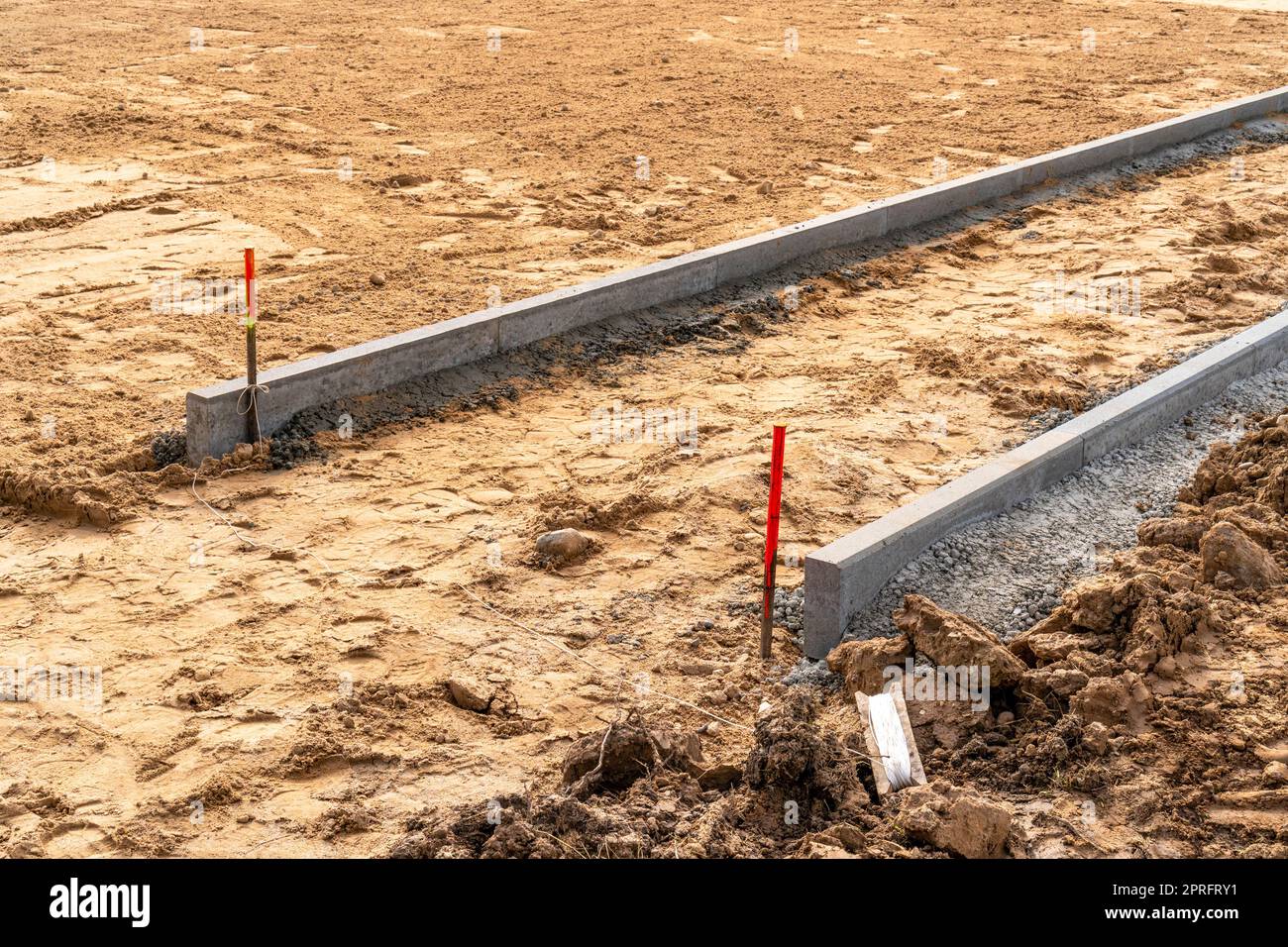A sidewalk is under construction, a concrete curb is being installed ...